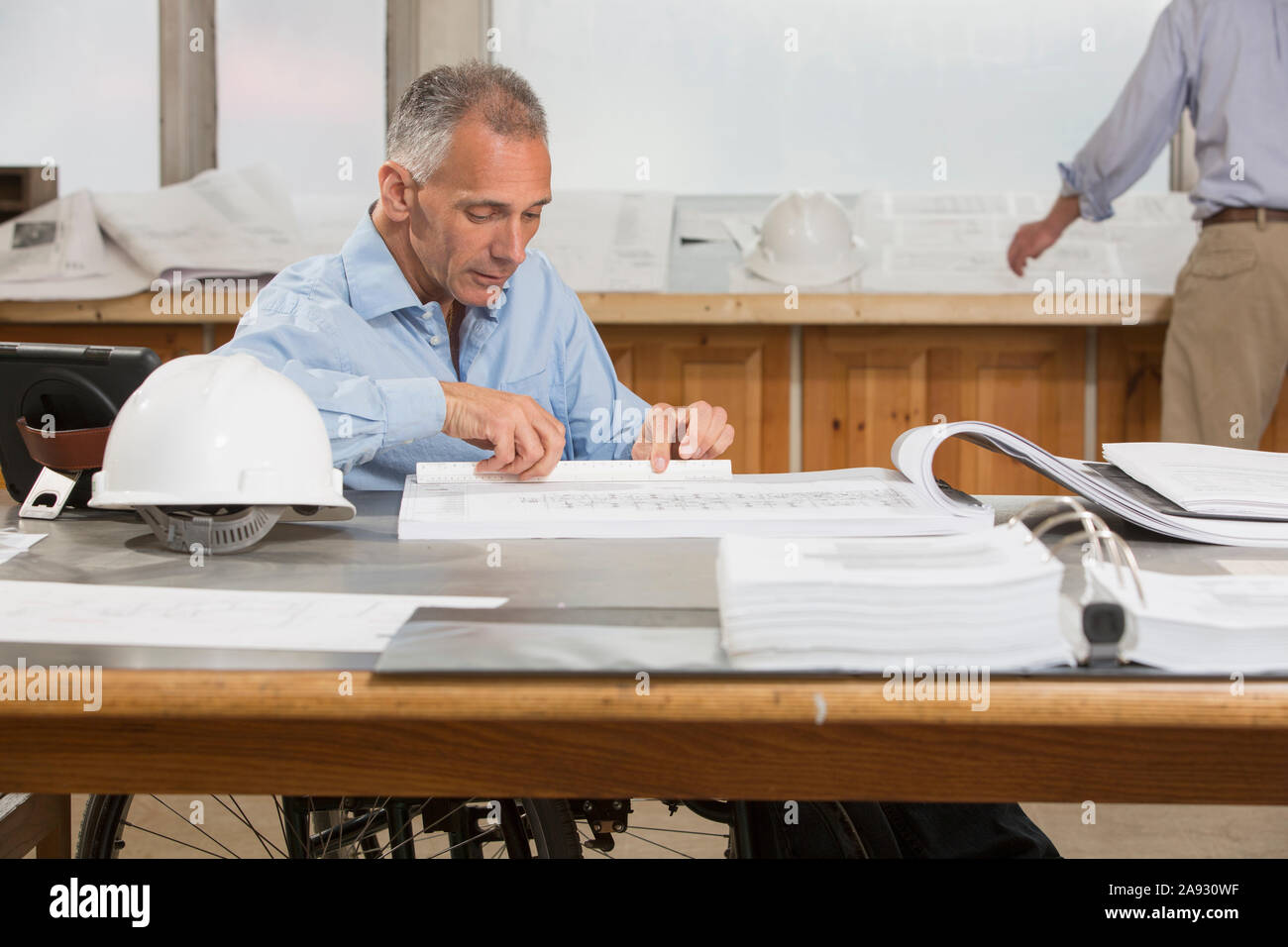 Two project engineers doing paperwork about the job, one in a ...