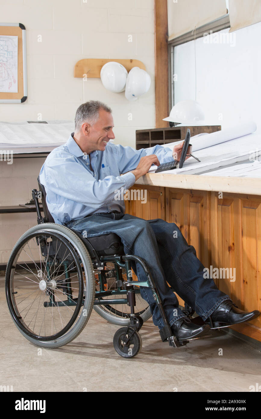Project engineer using tablet to check job site plans, while in a ...