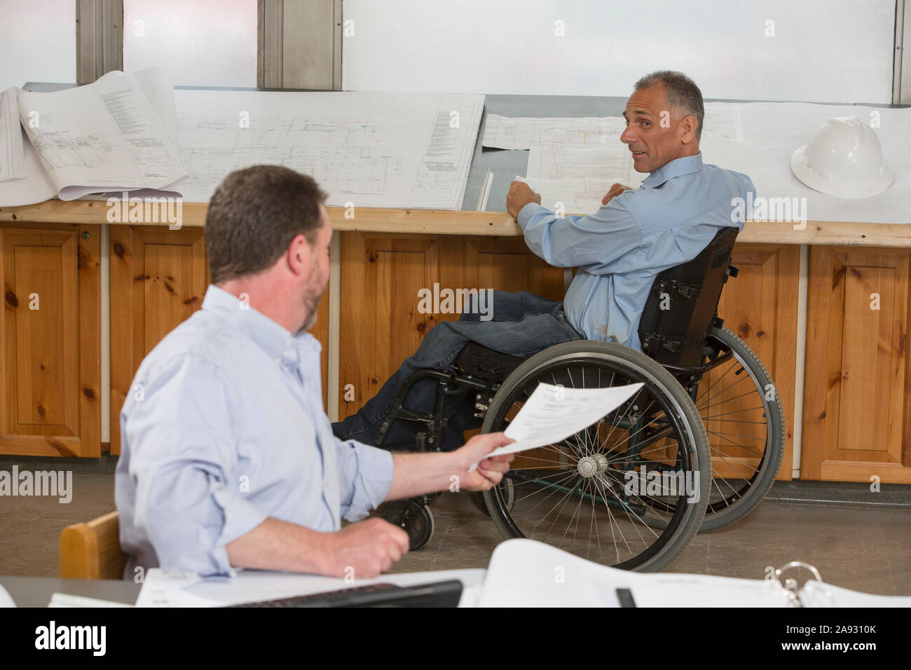 Two project engineers doing paperwork about the job, one in a ...