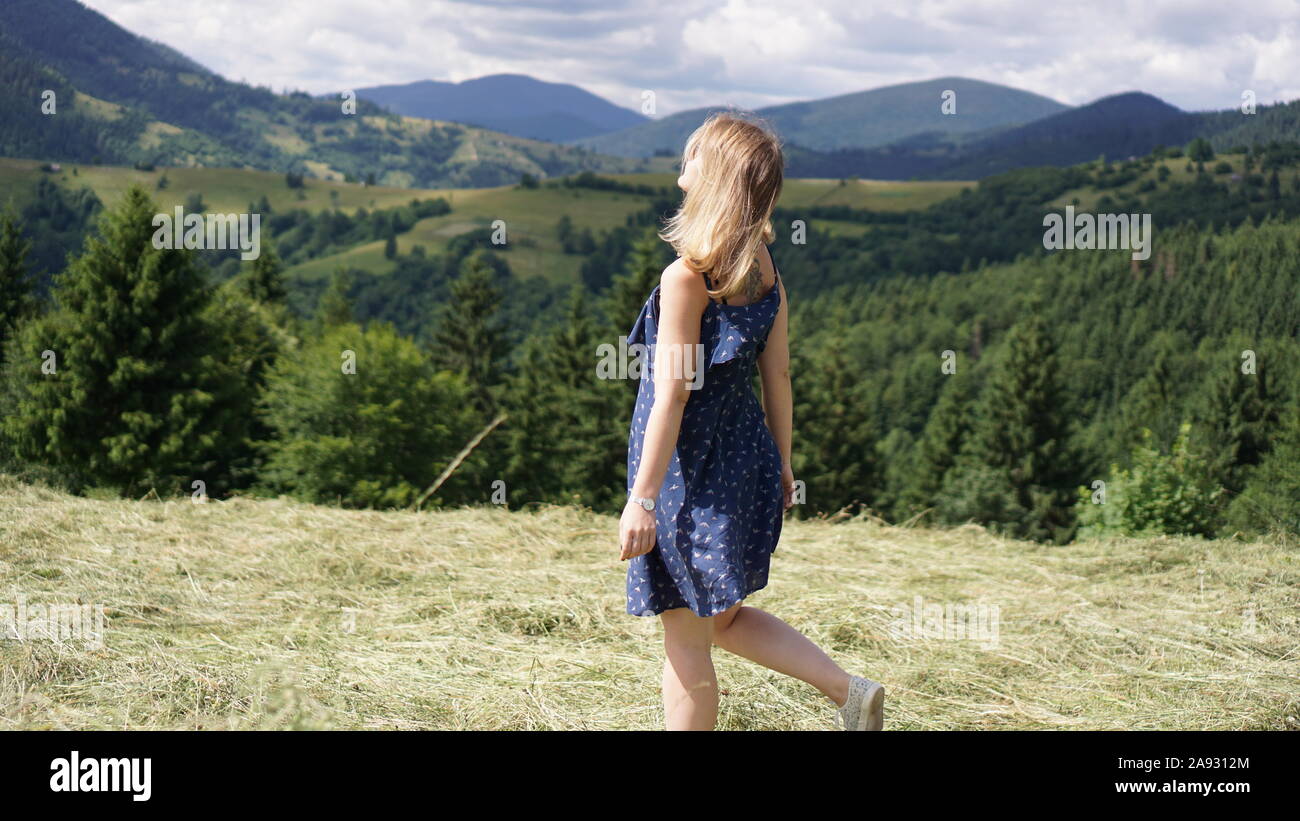 Happy Woman standing on the mountain top looking at panoramic view of ...