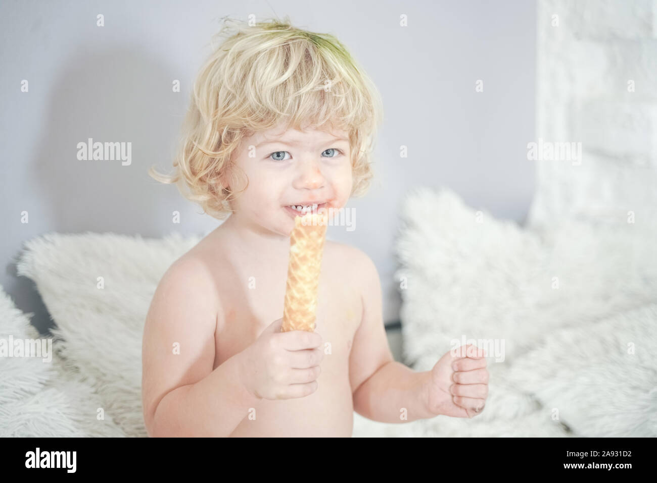 little child taking waffle and eating it with pleasure and fun on white ...