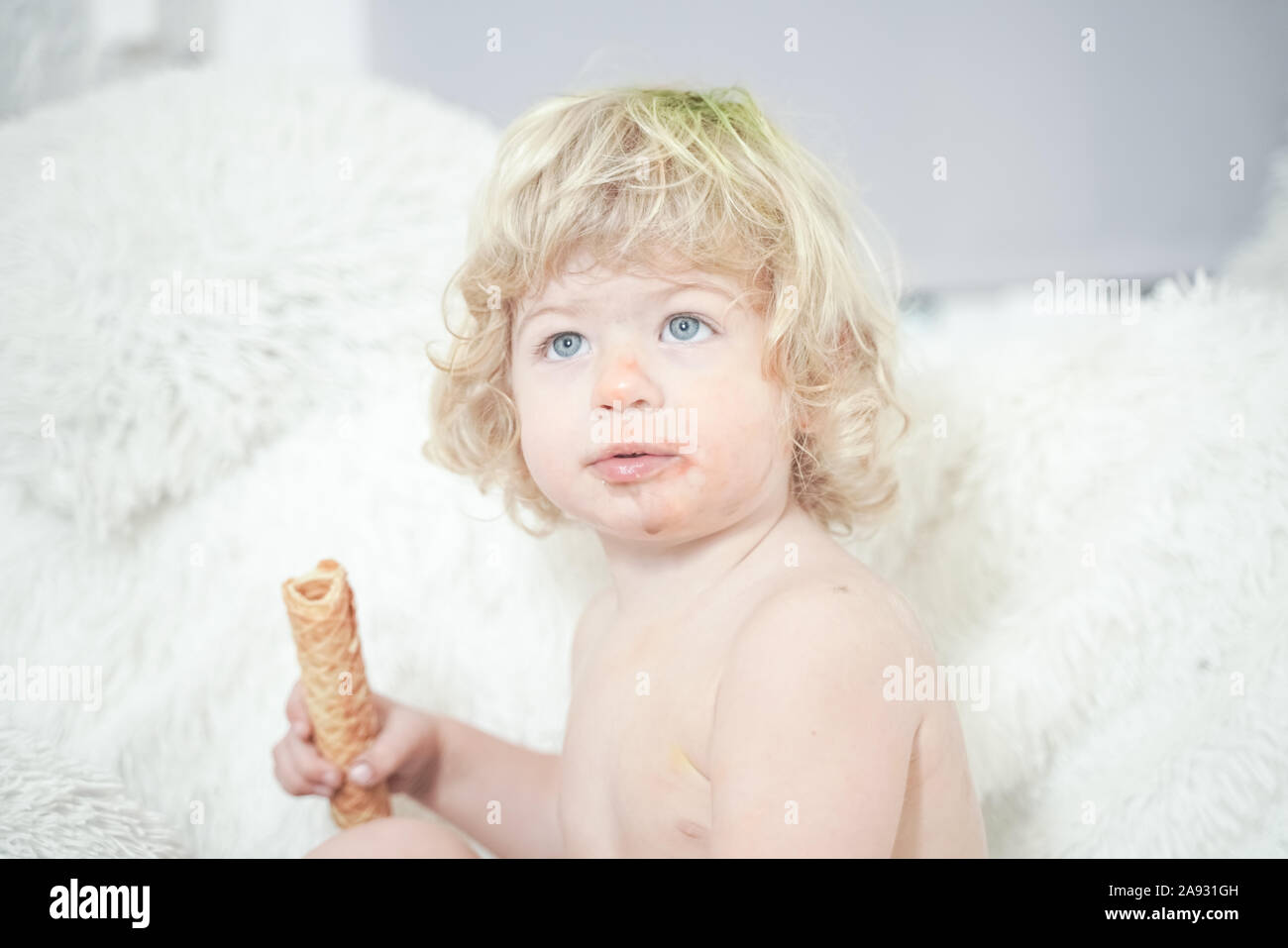 little child taking waffle and eating it with pleasure and fun on white ...