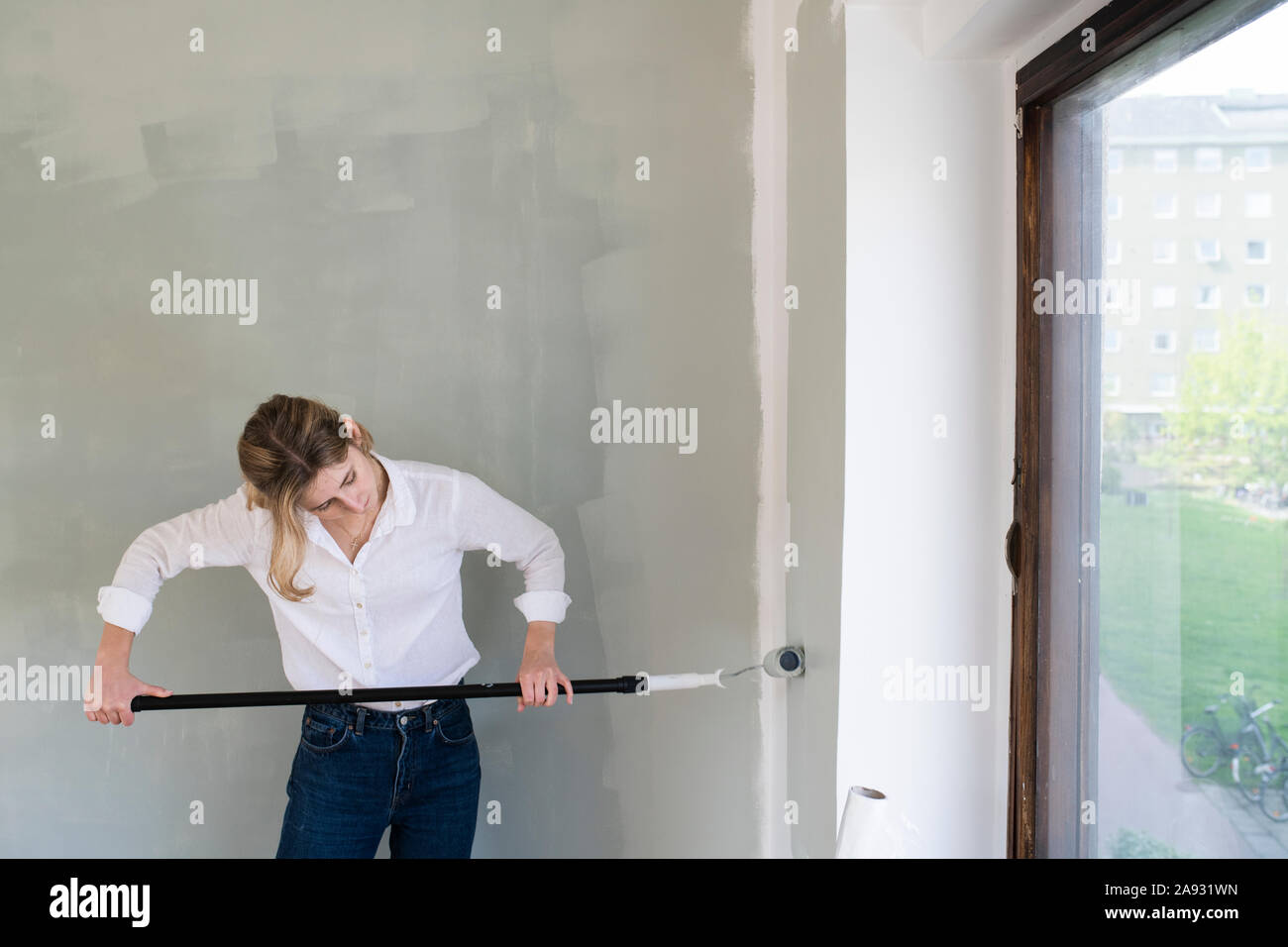 Woman long roller painting hi-res stock photography and images - Alamy