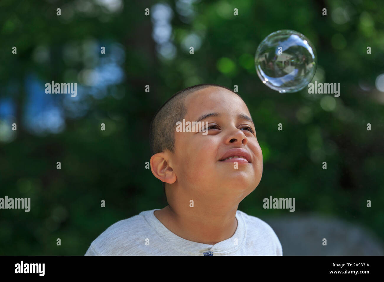 Happy Hispanic boy with Autism playing with a bubble in park Stock ...