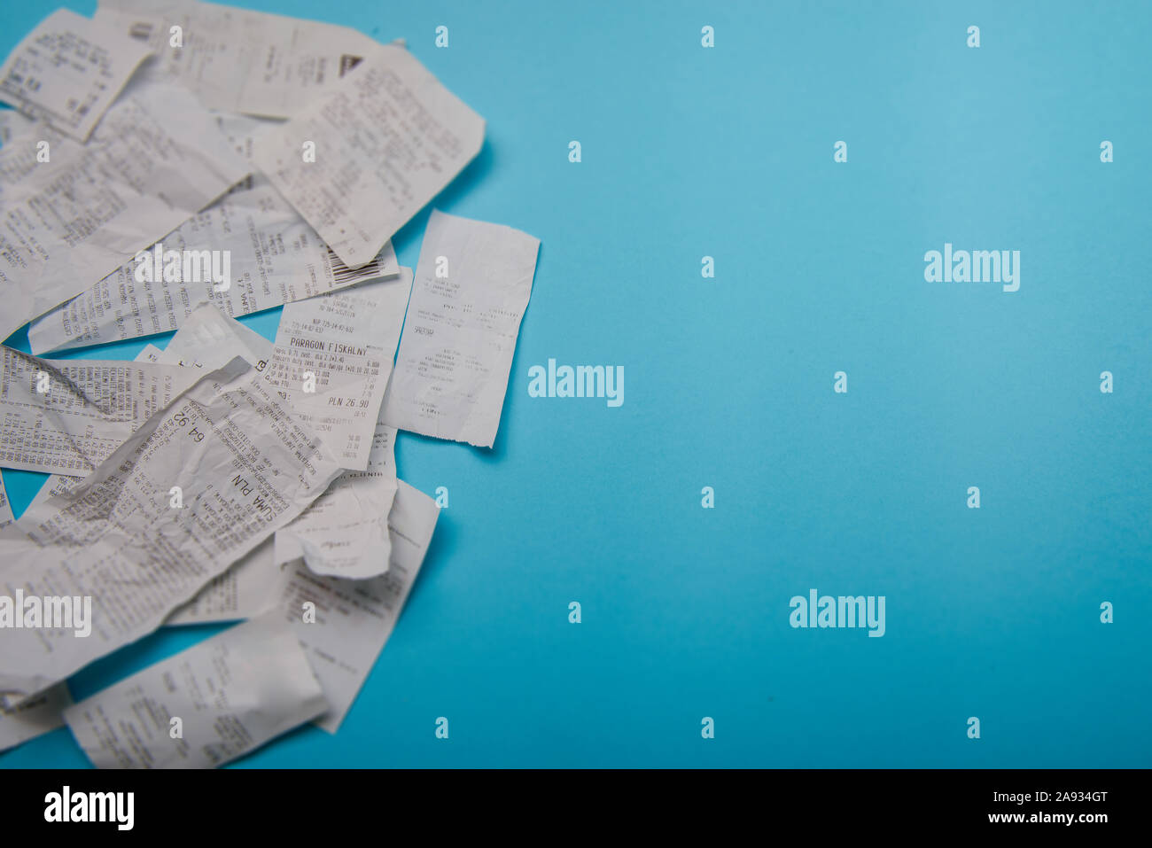 Pile of shopping receipts on a blue background Stock Photo - Alamy