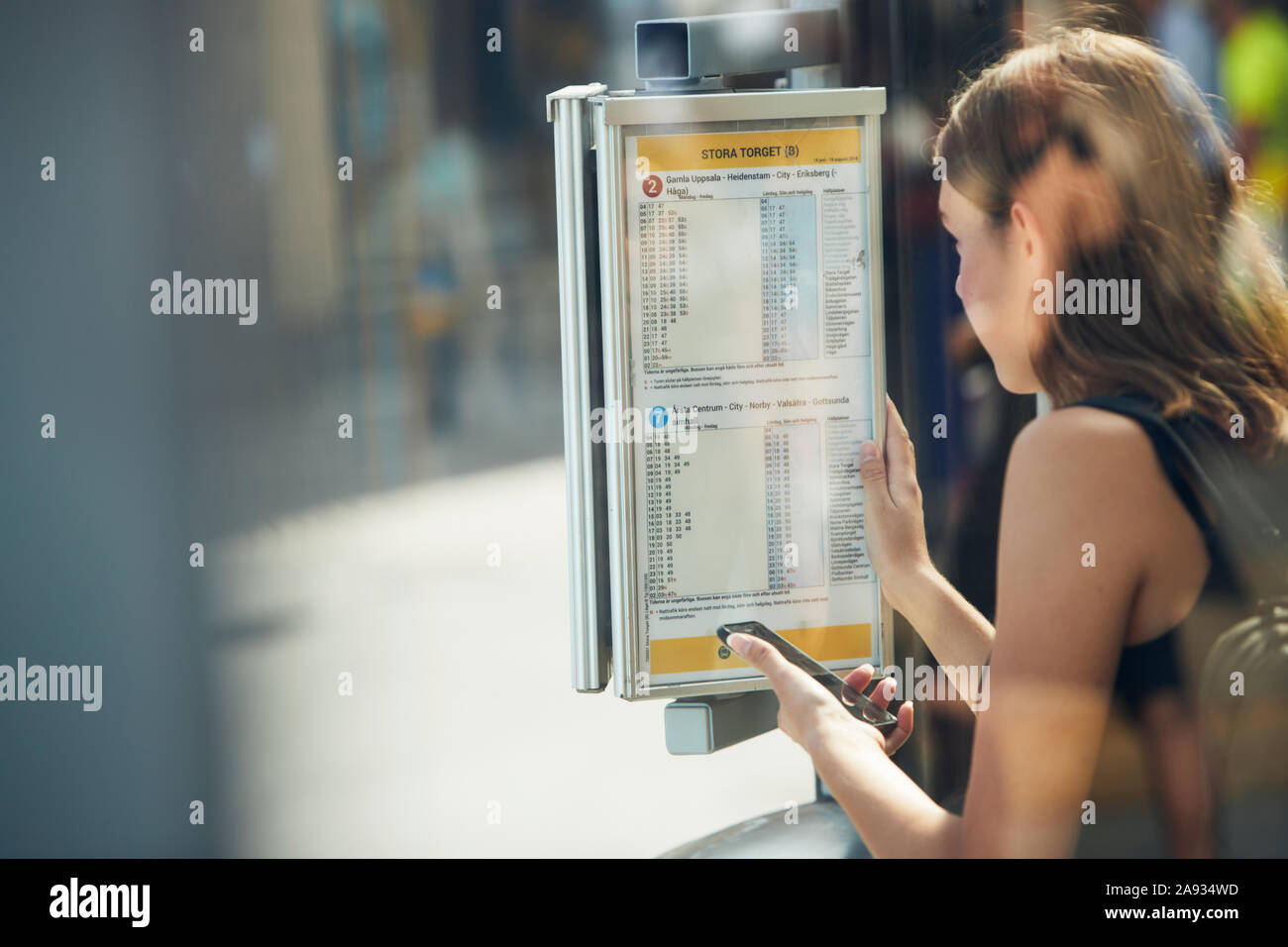 Woman checking timetable Stock Photo - Alamy