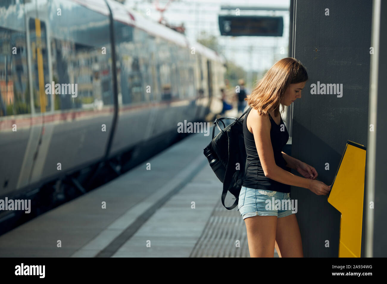 Woman buying ticket on train platform Stock Photo - Alamy
