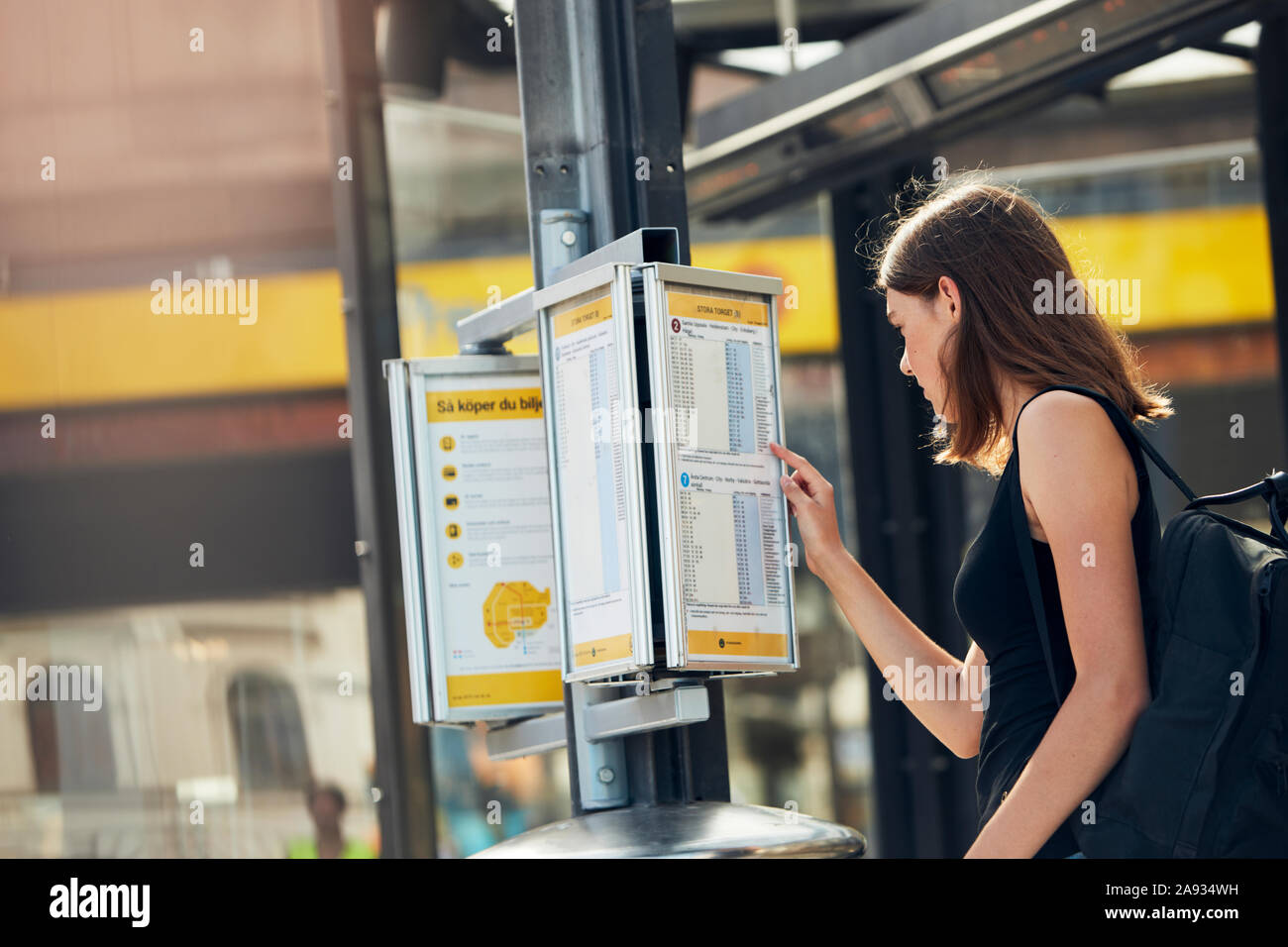 Woman checking timetable Stock Photo - Alamy