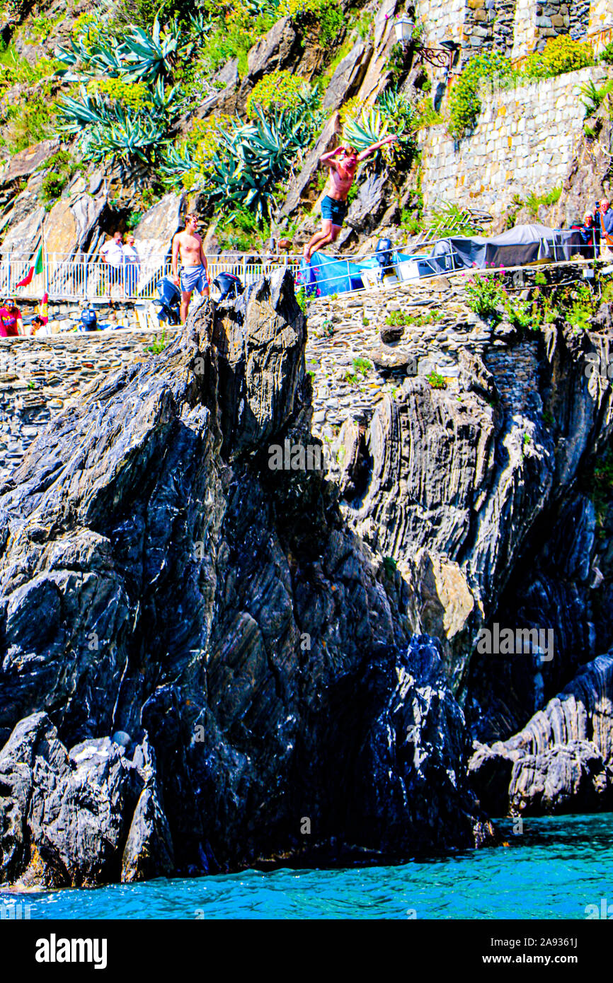 editorial use only of a cliff diver in Italy, near a small village in ...
