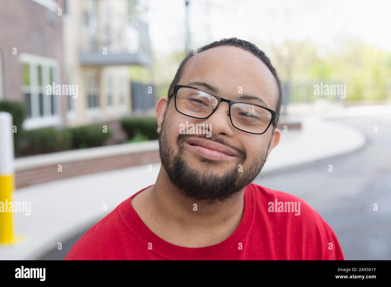 Portrait of happy African American man with Down Syndrome outdoors ...