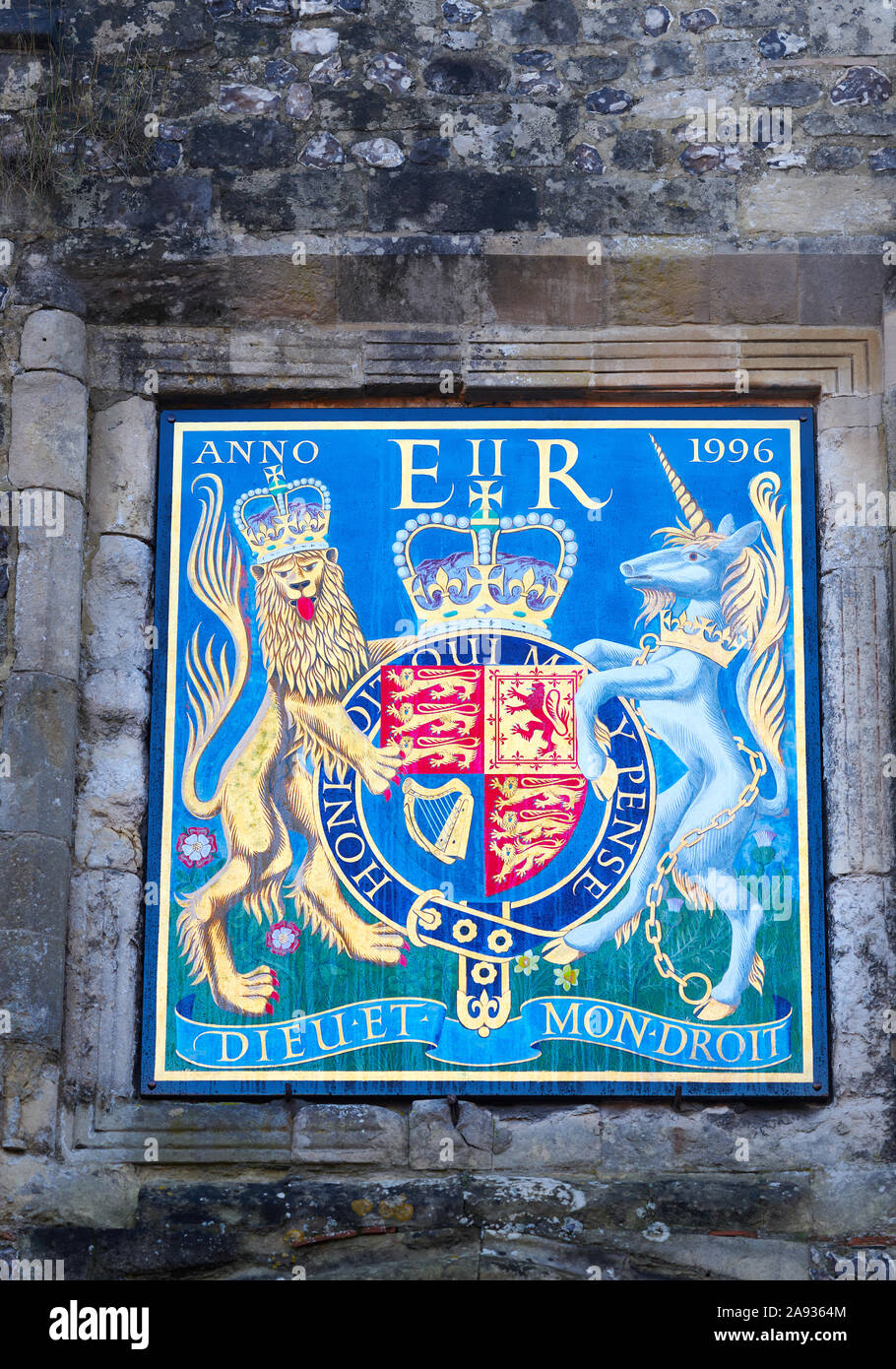 Royal coat of arms (including order of garter emblem) on a stone wall ...