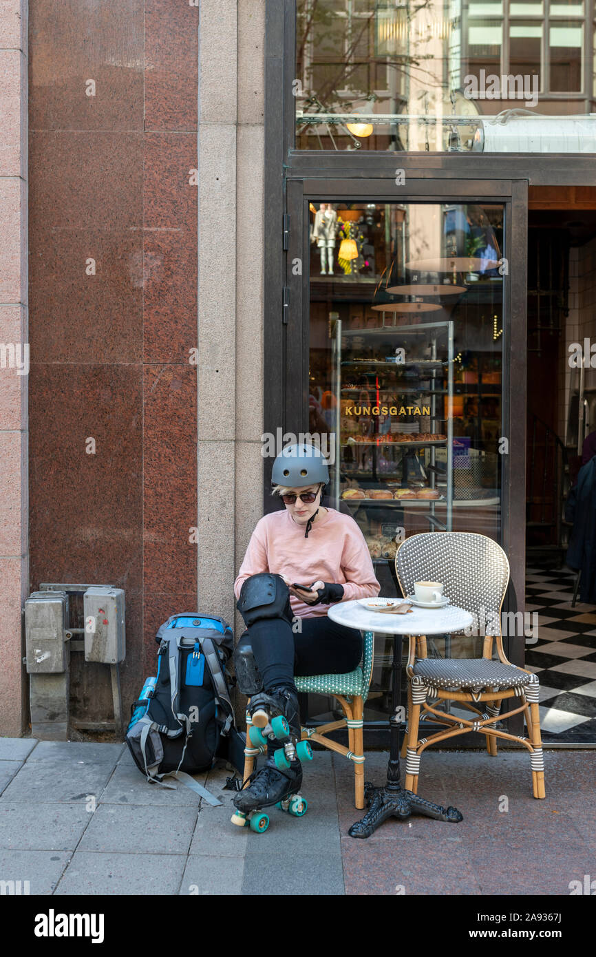 Female skater in outdoor cafe Stock Photo - Alamy