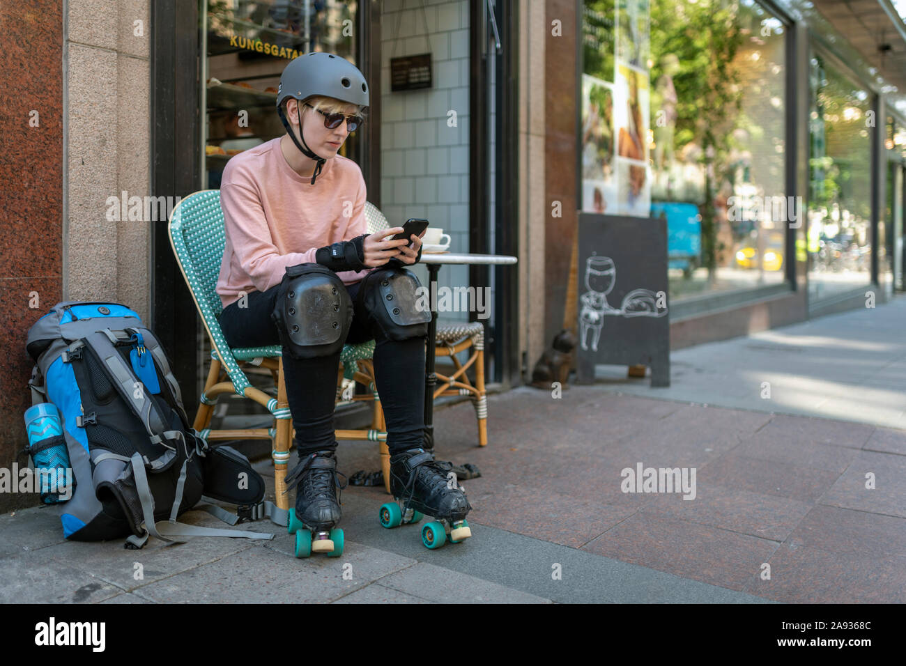 Female skater in outdoor cafe Stock Photo - Alamy