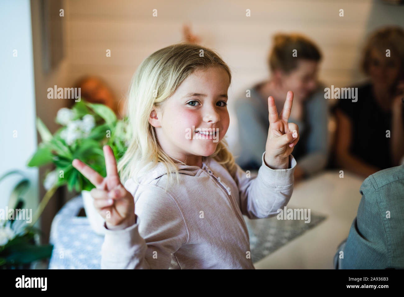 Girl making peace sign Stock Photo - Alamy