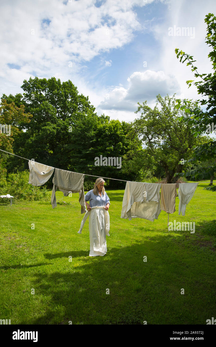 Woman hanging laundry Stock Photo - Alamy
