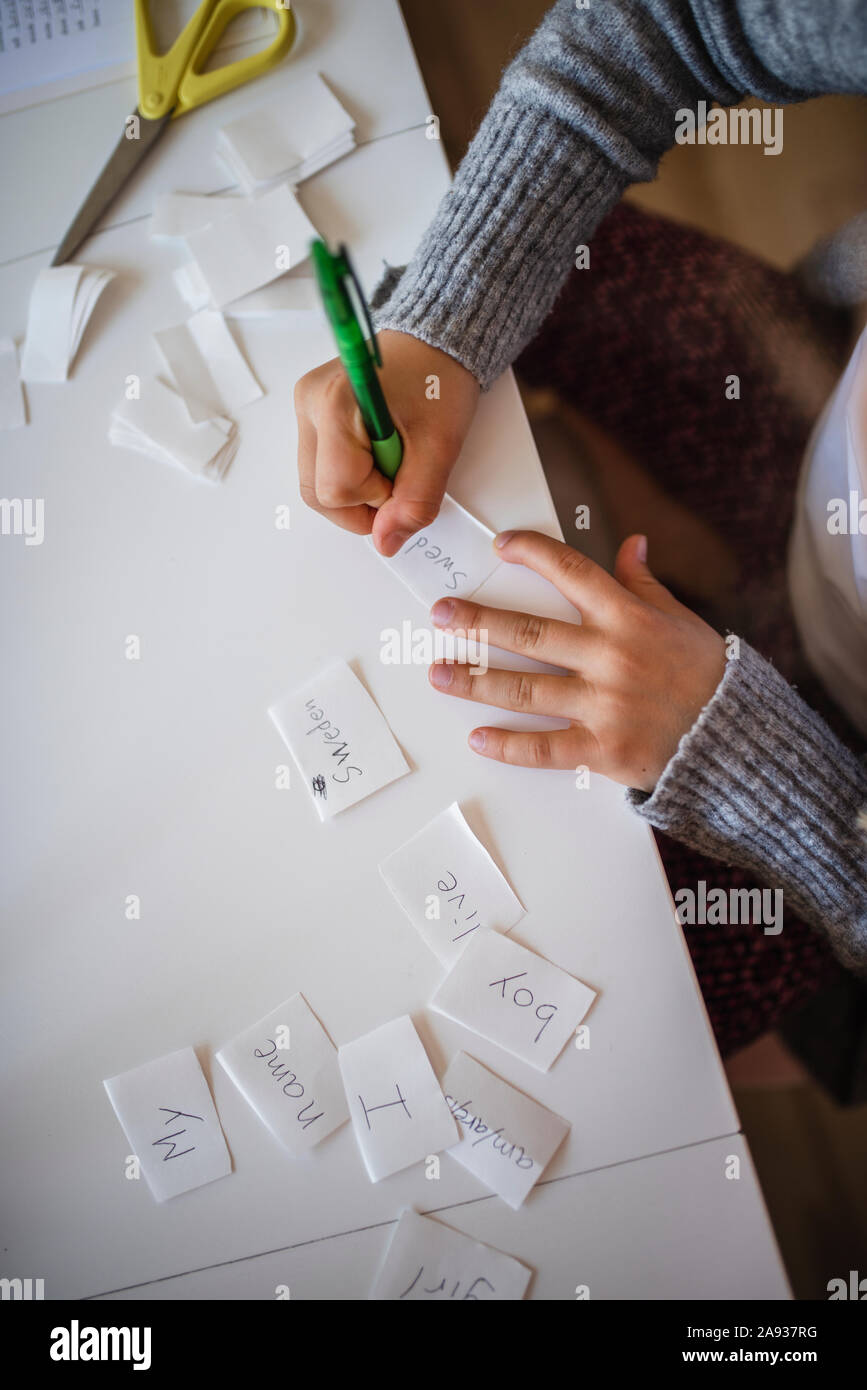 Girl writing on pieces of paper Stock Photo - Alamy