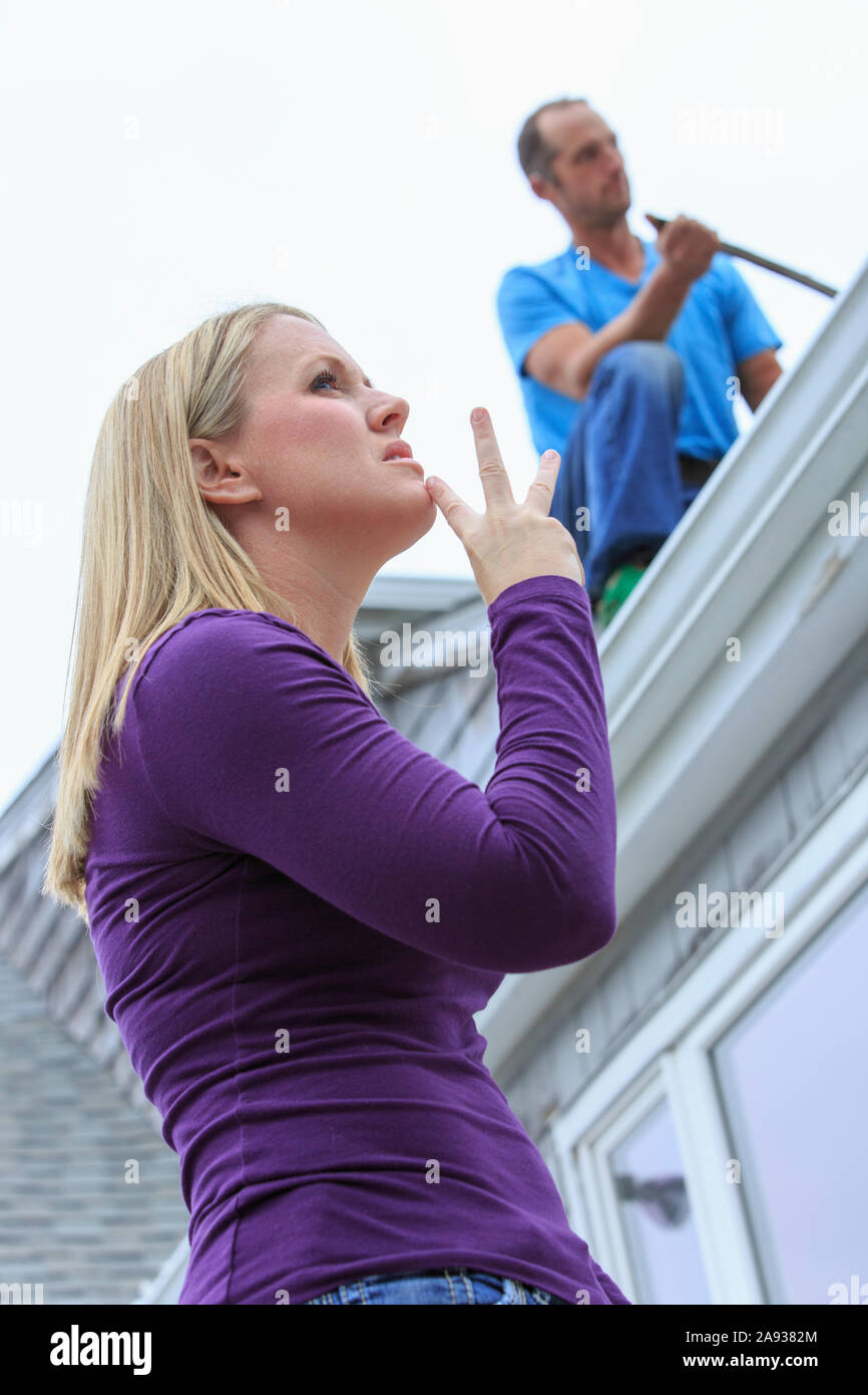 Homeowner signing 'New' in American Sign Language to a roofer with ...