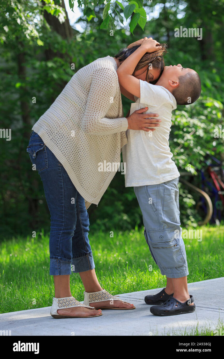 Hispanic boy with Autism hugging his mother in park Stock Photo - Alamy