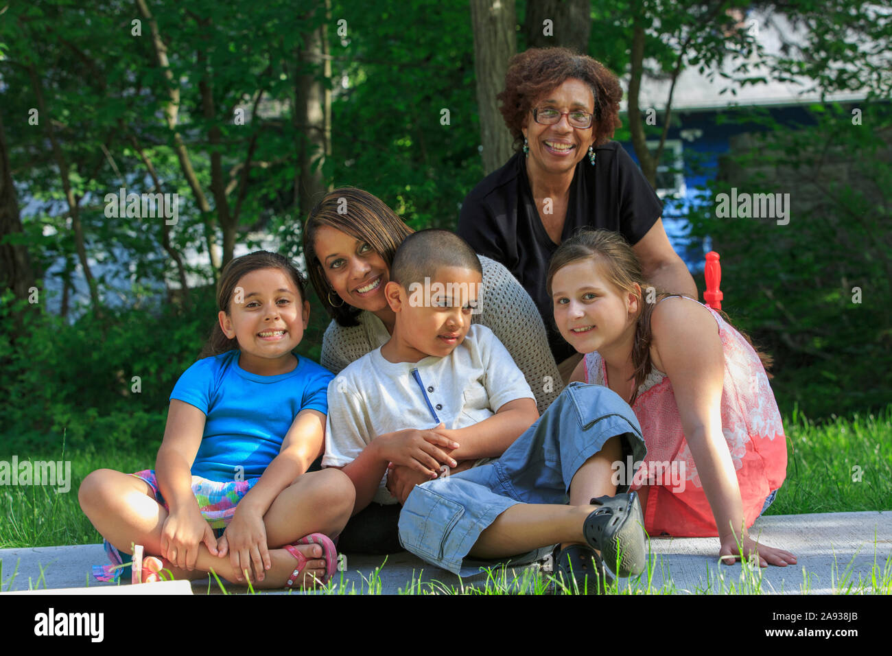 Happy Hispanic family with Autistic boy sitting together in a park ...