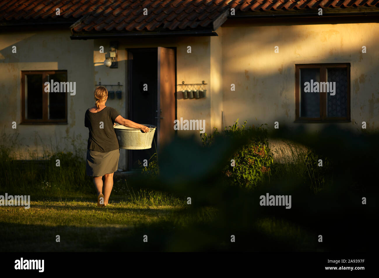 Woman in front of house Stock Photo - Alamy