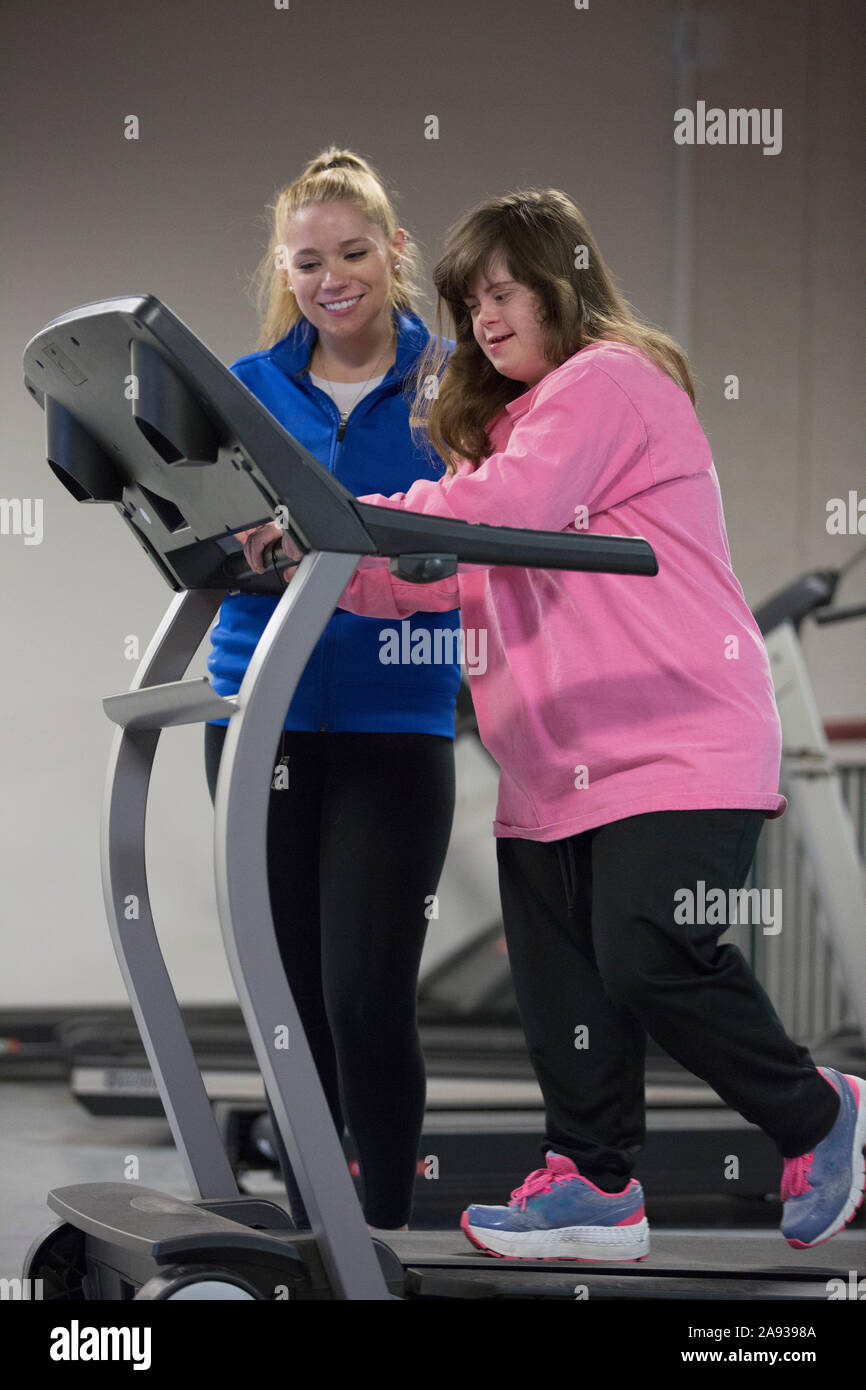 Young woman with Down Syndrome working out with her trainer on an ...
