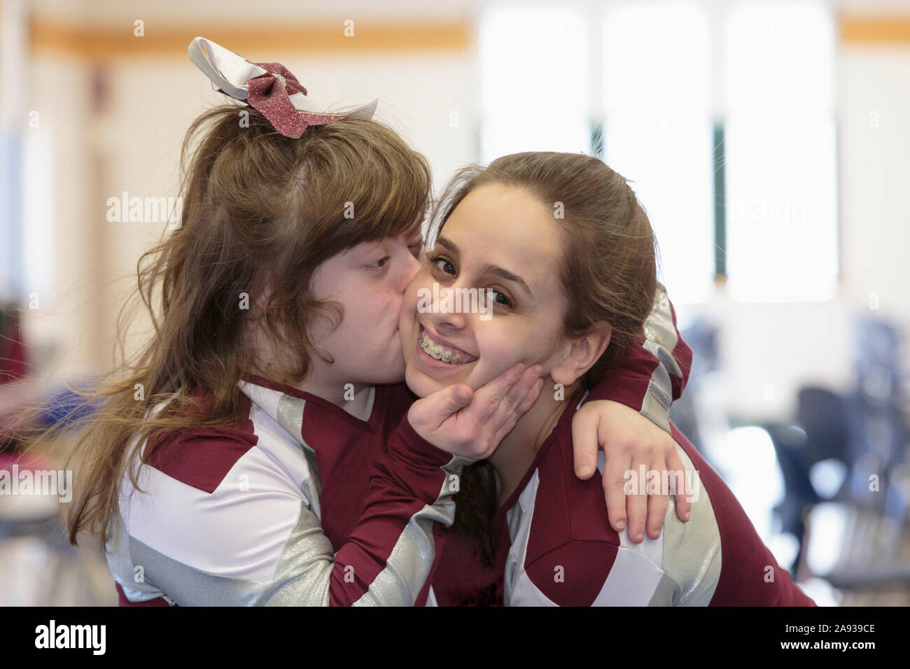 Cheerleader with Down Syndrome kissing another cheerleader Stock Photo ...