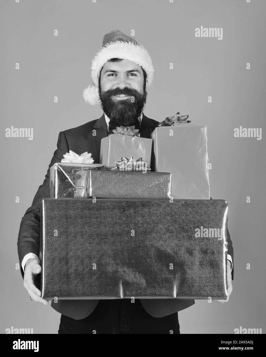 Manager with beard and pile of Christmas gifts. Man in smart suit and ...