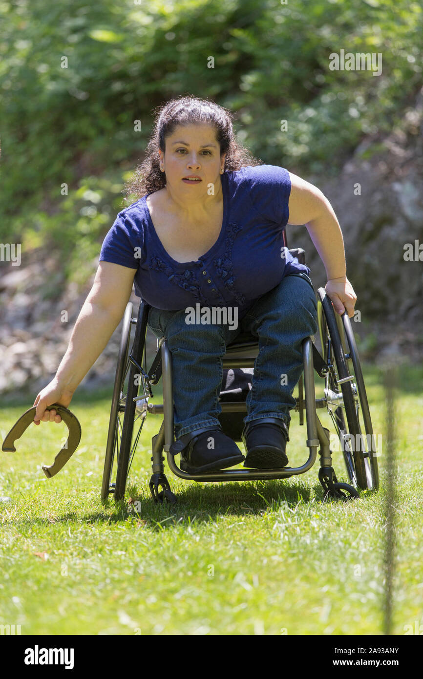 Woman with Spina Bifida in a wheelchair playing horseshoes Stock Photo ...