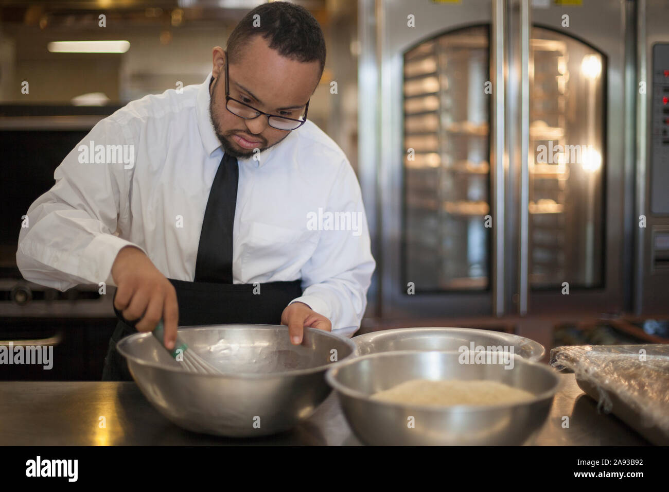 African American man with Down Syndrome as a chef cooking in commercial ...