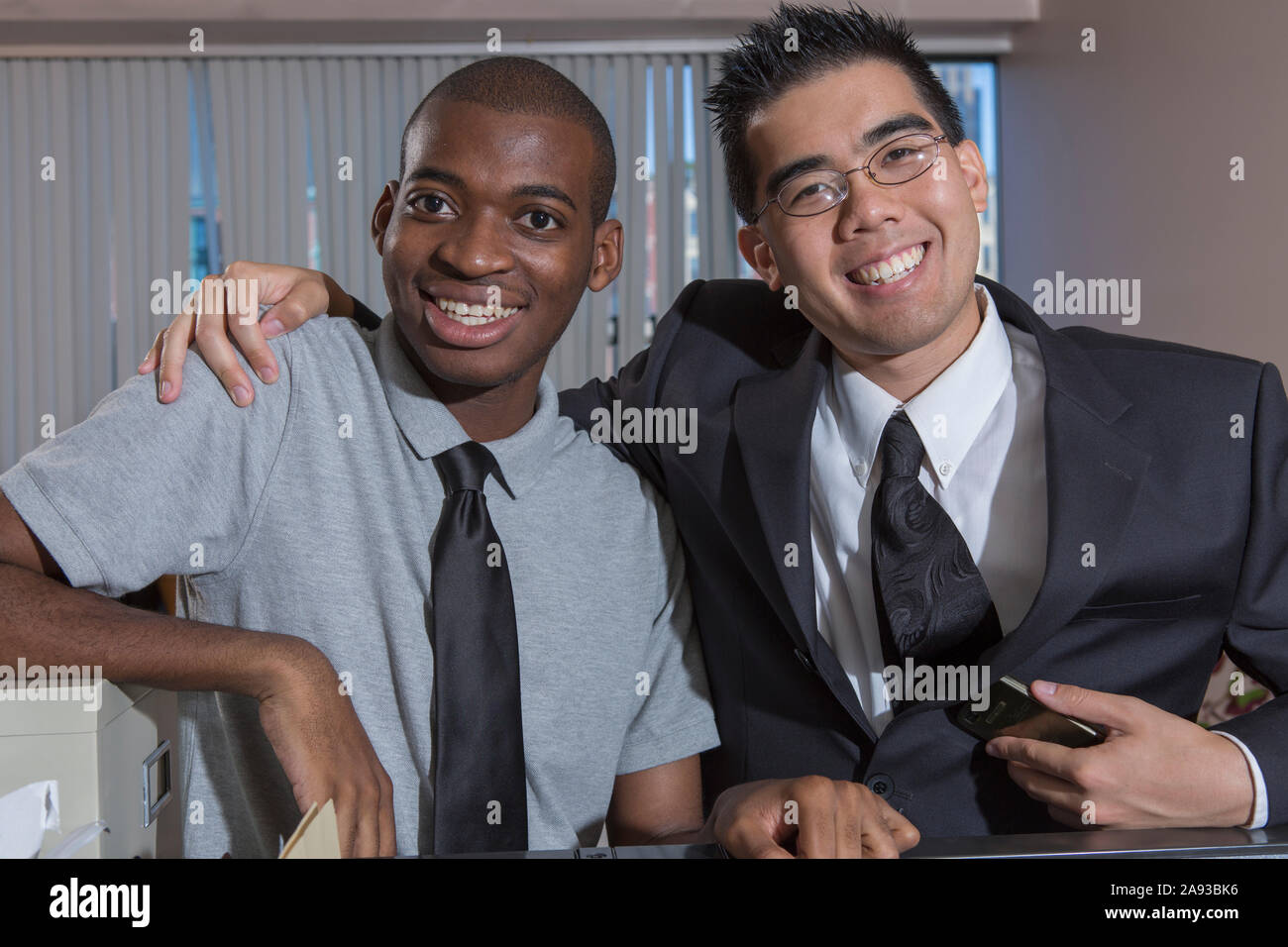 Happy portrait of two men with Autism smiling in an office Stock Photo ...
