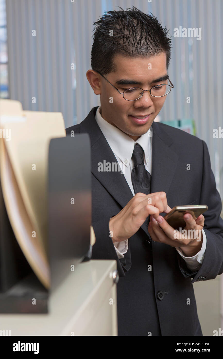Happy Asian man with Autism using his phone in an office Stock Photo ...