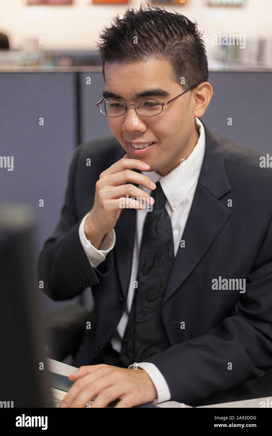 Asian man with Autism working on computer in an office Stock Photo - Alamy