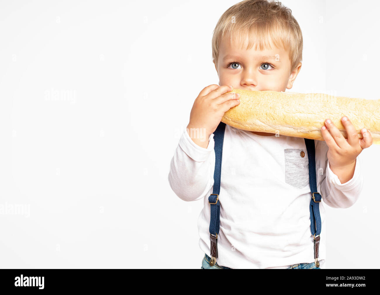 Funny baby boy eating a loaf of bread in studio. Isolated on white ...
