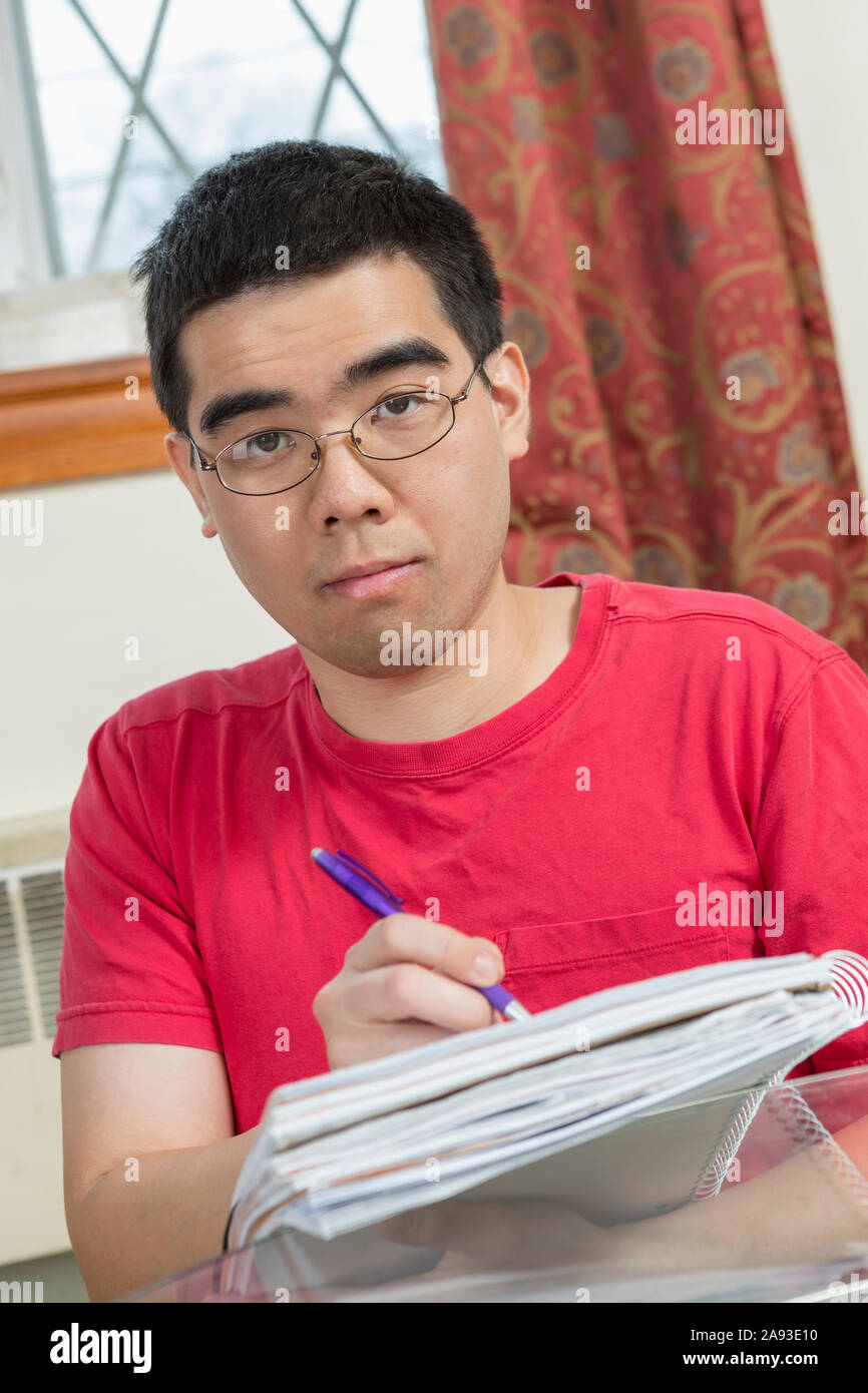 Portrait of Asian man with Autism working on his homework Stock Photo ...
