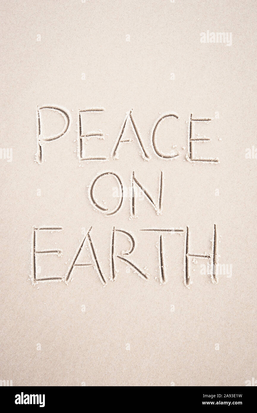 Peace On Earth holiday message handwritten on smooth sand beach Stock ...
