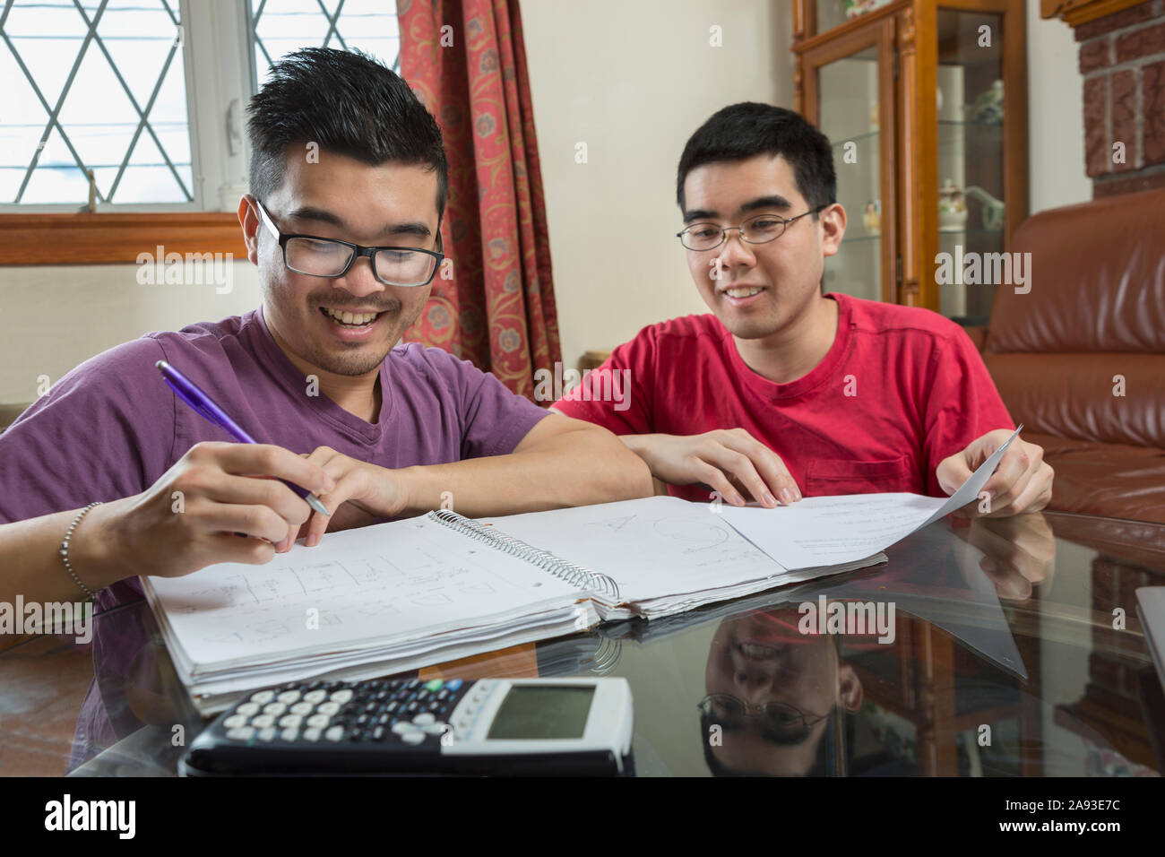 Asian man with Autism working on his homework with his brother Stock ...