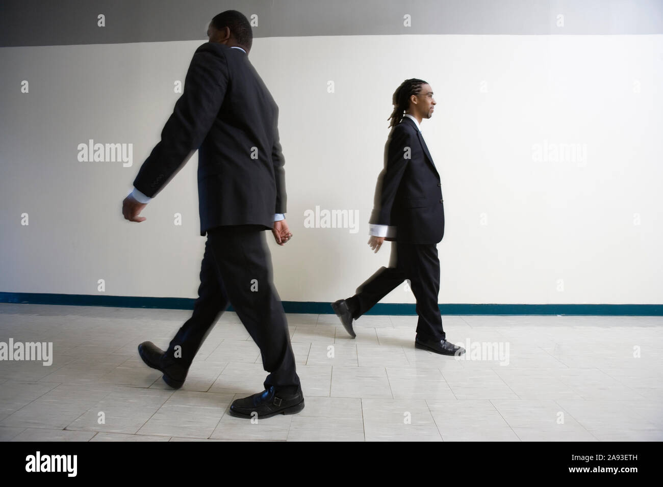 Young business men walking in the corridor Stock Photo - Alamy