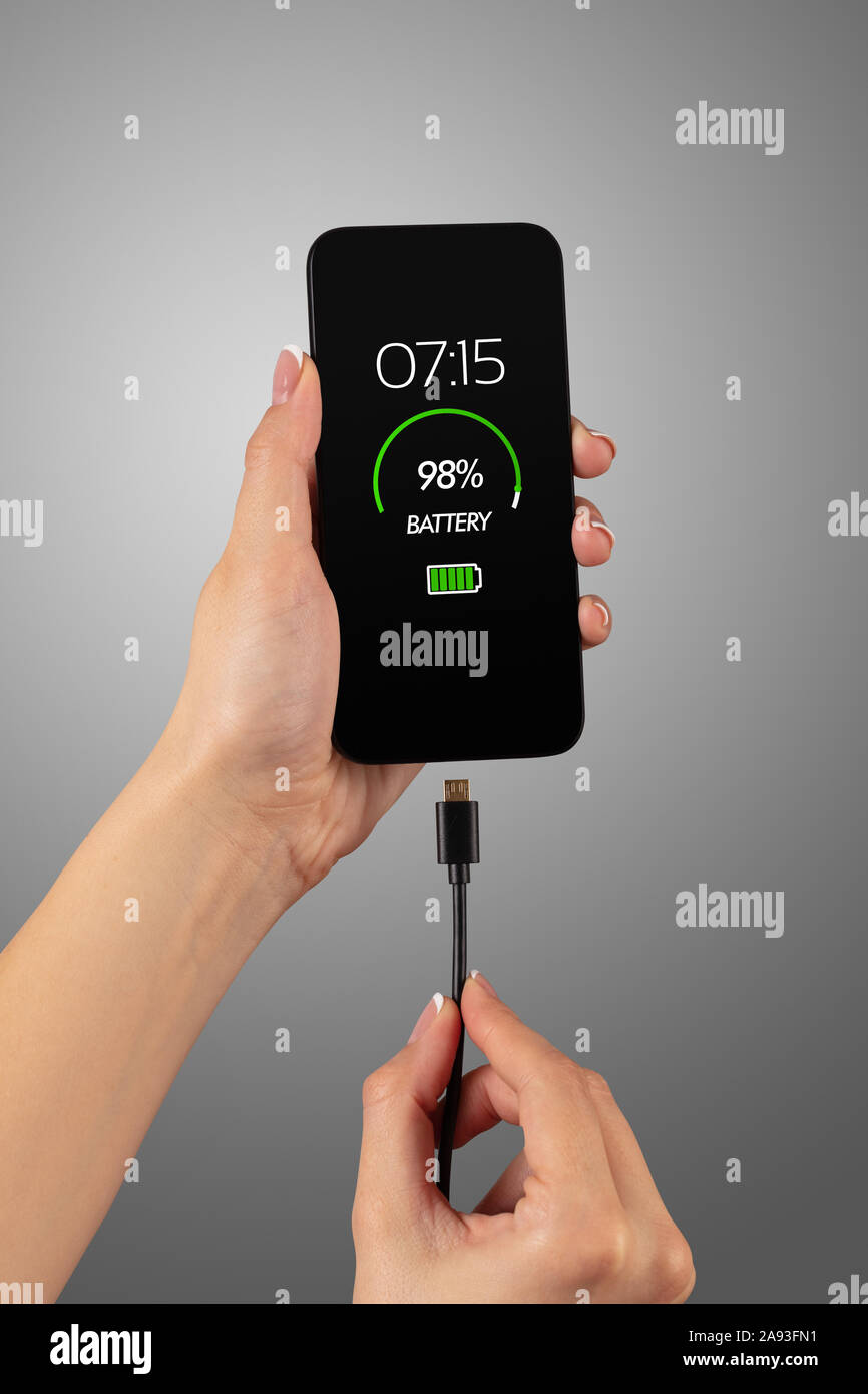 Elegant hand charging cellphone with low battery Stock Photo - Alamy