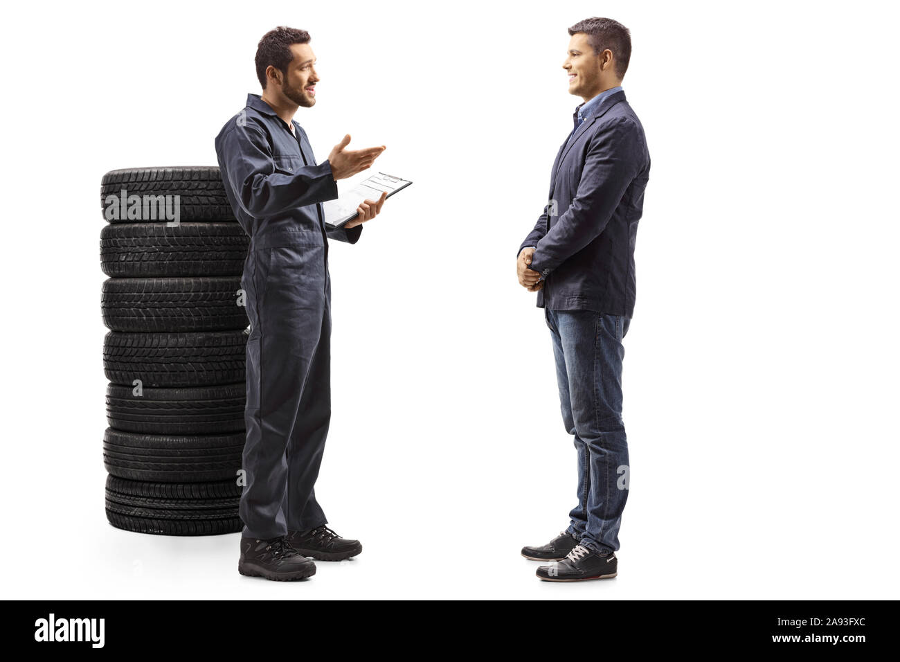 Full length profile shot of an auto mechanic talking to a male customer ...
