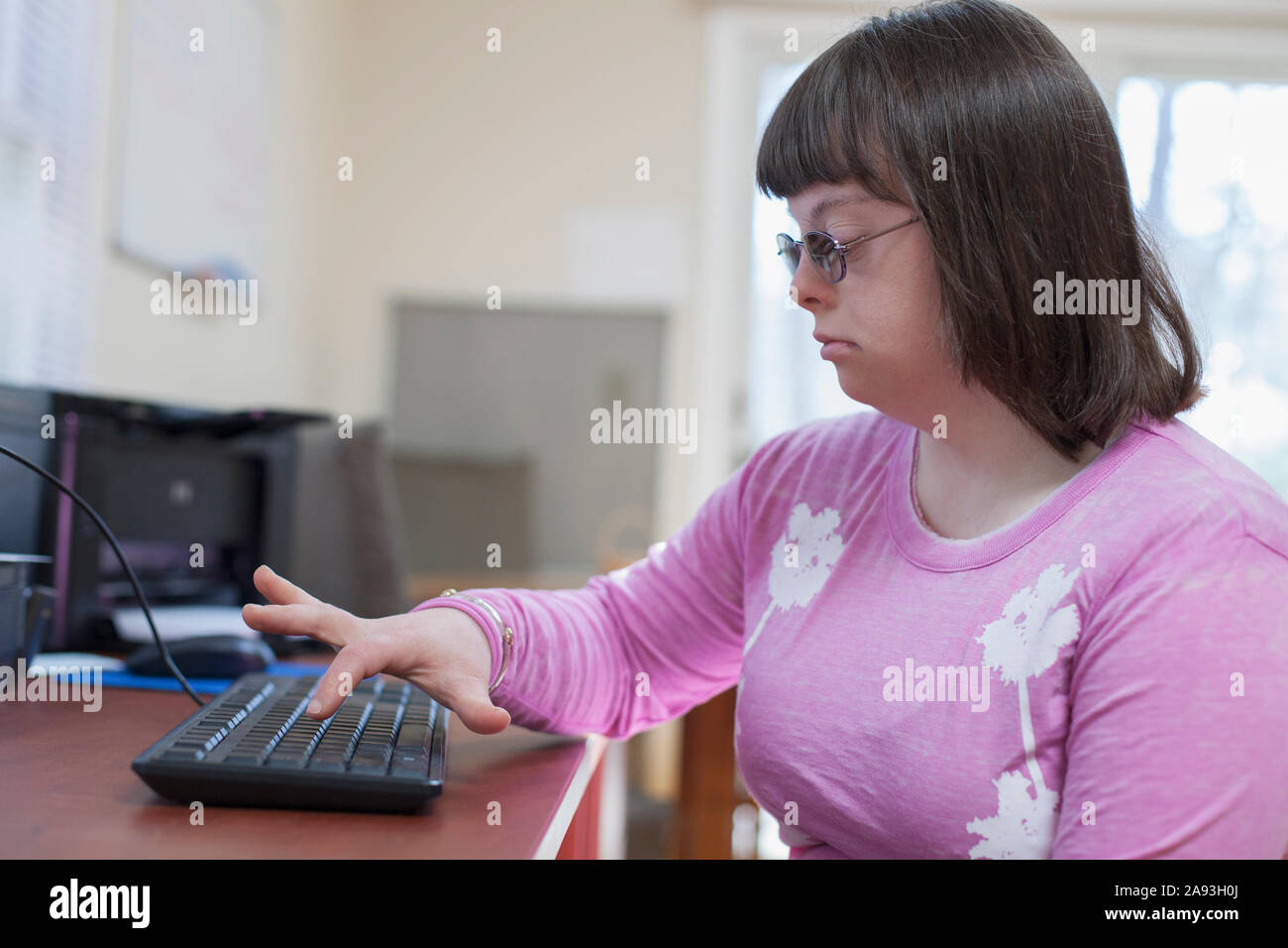 Girl with down syndrome using computer hi-res stock photography and ...