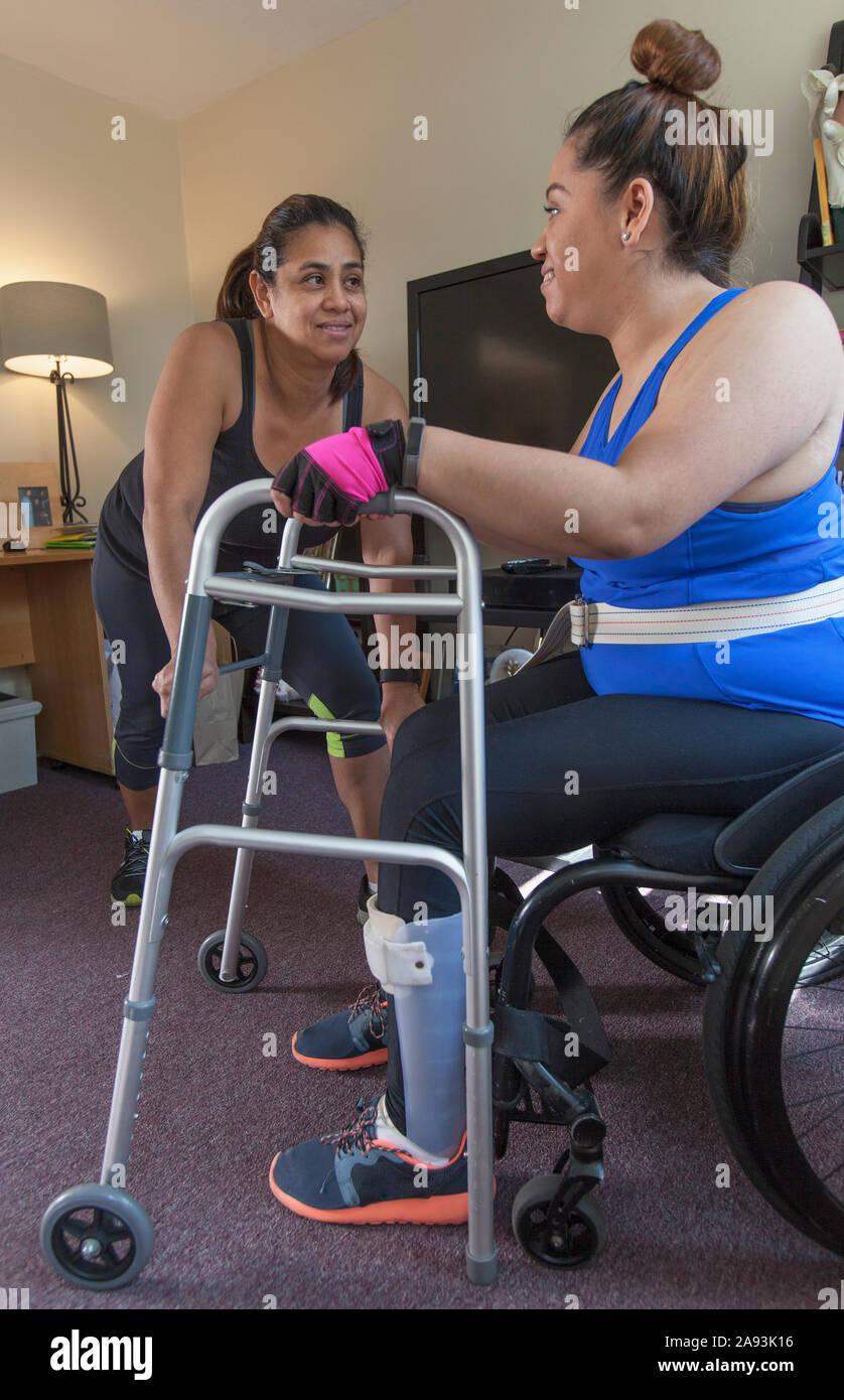Woman with spinal cord injury getting up into her walker Stock Photo ...