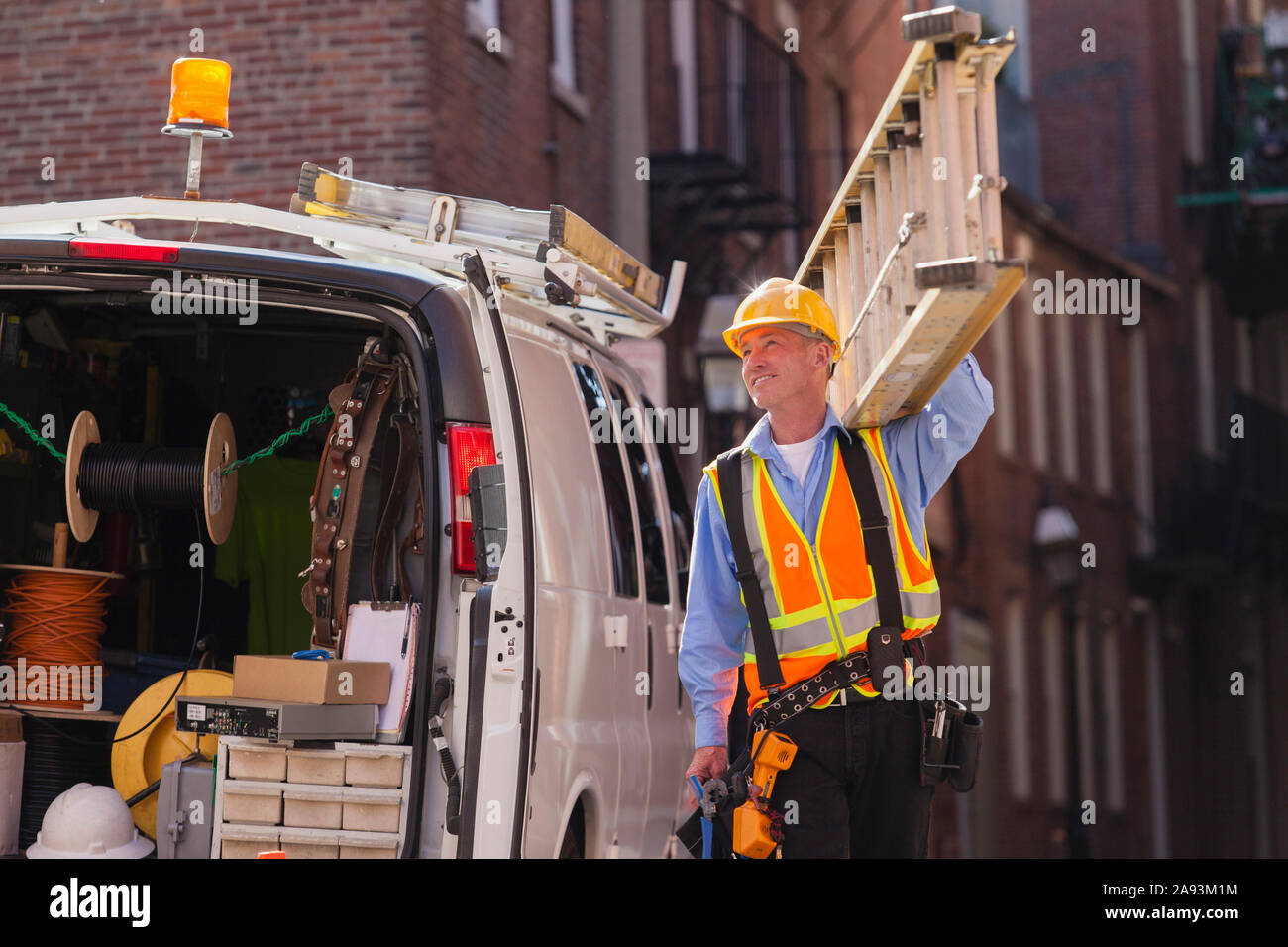Cable installer preparing to climb the line with ladder Stock Photo - Alamy