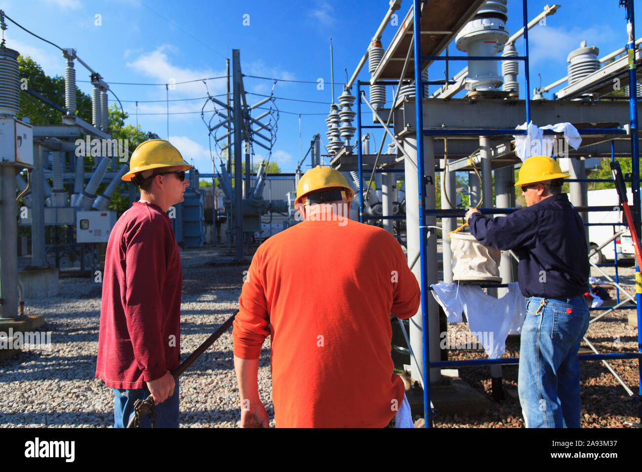 Power engineers working at high voltage power distribution station ...