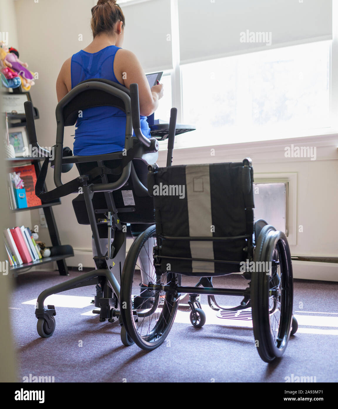 Woman with spinal cord injury working at home at her stand up desk ...