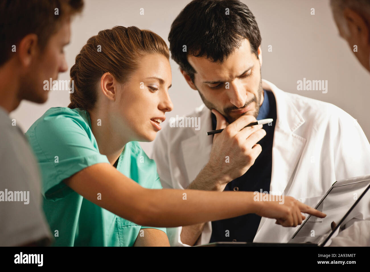 Small group of doctors and nurses talking and brainstorming together ...