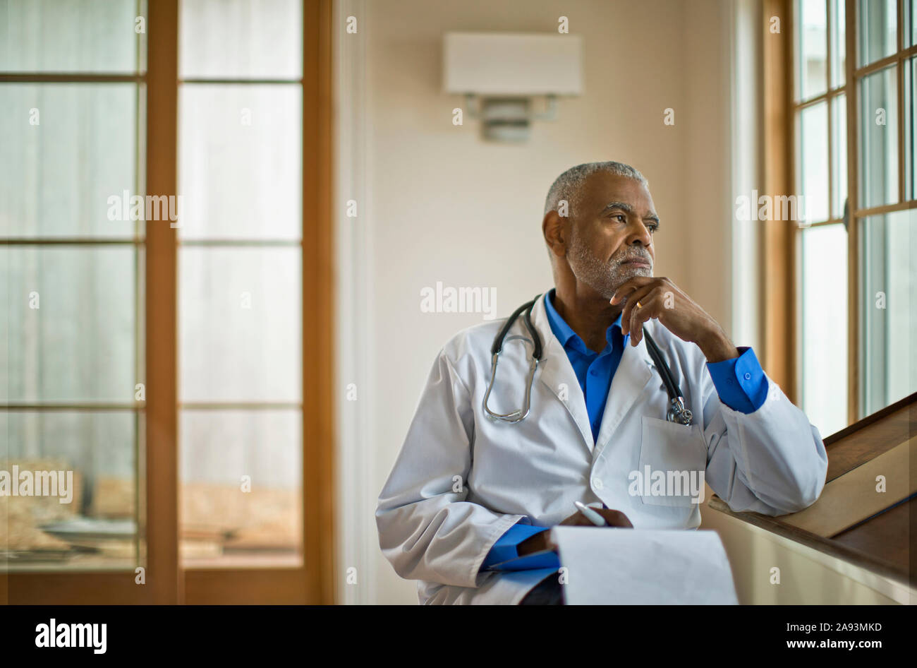Doctor sitting and looking out the window Stock Photo - Alamy