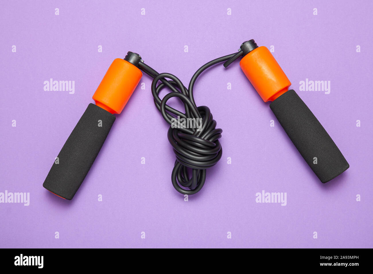 Jump rope. Fun exercises for body health. Orange rope with black cord ...