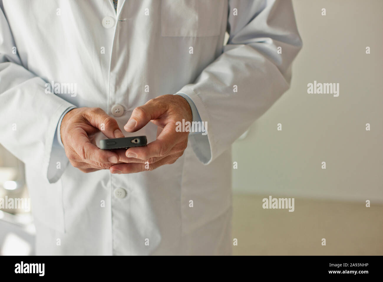 Doctor checking his mobile phone Stock Photo - Alamy