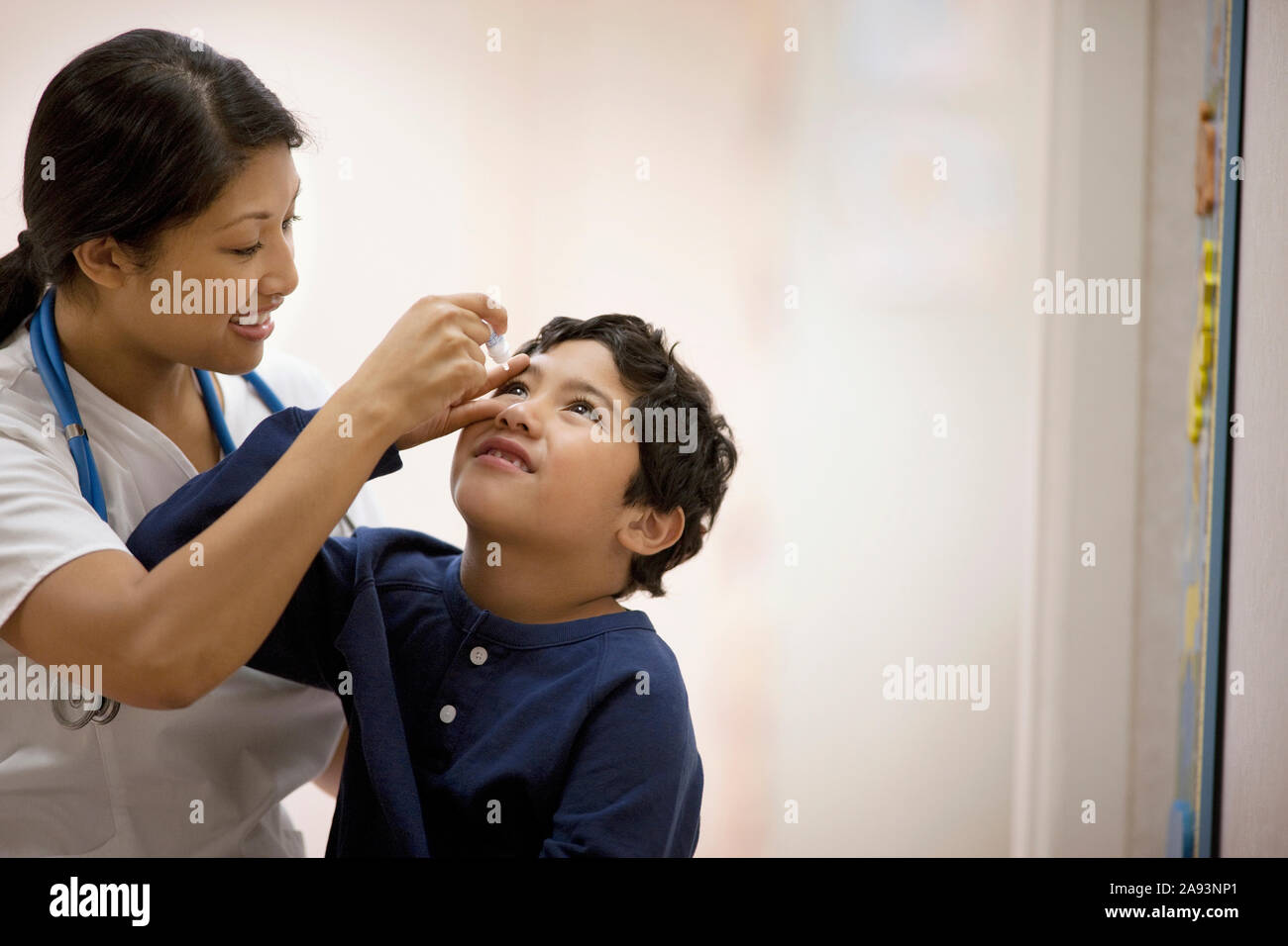 Nurse administering eye drops to a young boy Stock Photo - Alamy