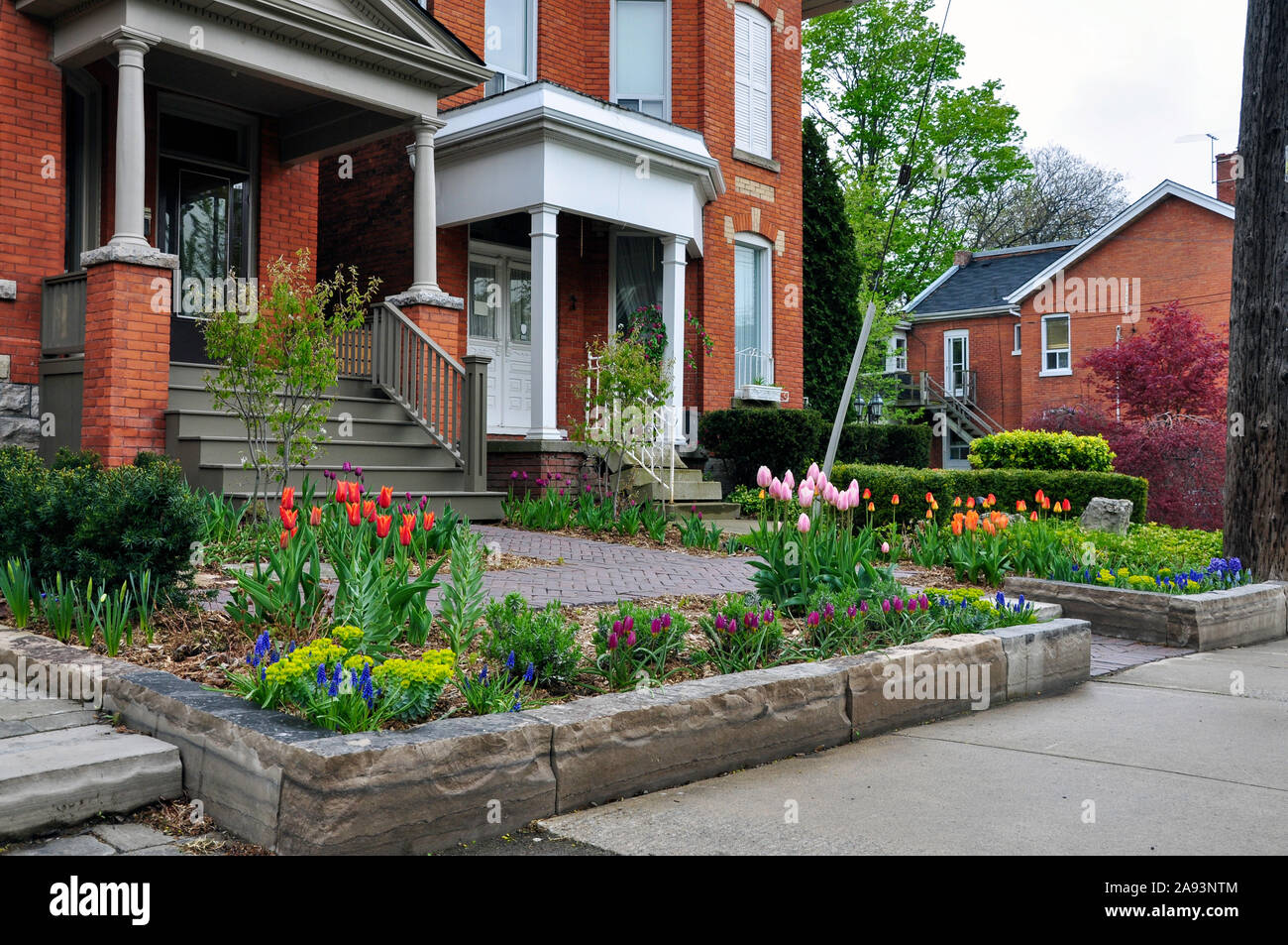 This beautiful, urban front yard garden features a large veranda, brick ...